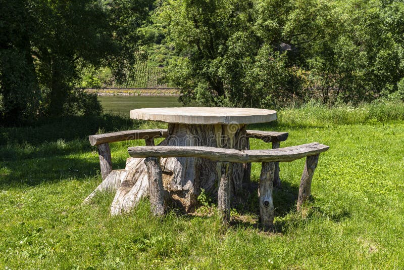 A Table Made of a Tree Trunk with a Concrete Top and Wooden Seats ...
