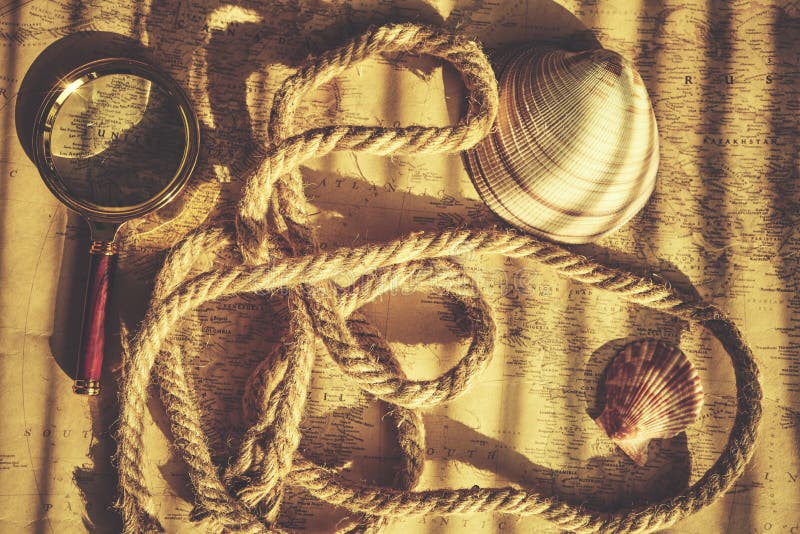 On Table, an Old Map is Pinned Down with Magnifying Glass, Shells, and ...