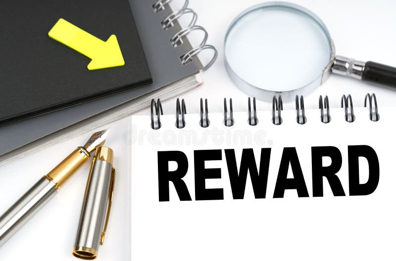 On the Table are a Pen and a Notebook with the Inscriptions - Reward ...