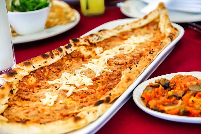 Table with Plates of Food and Large Pizza Stock Image - Image of lunch ...