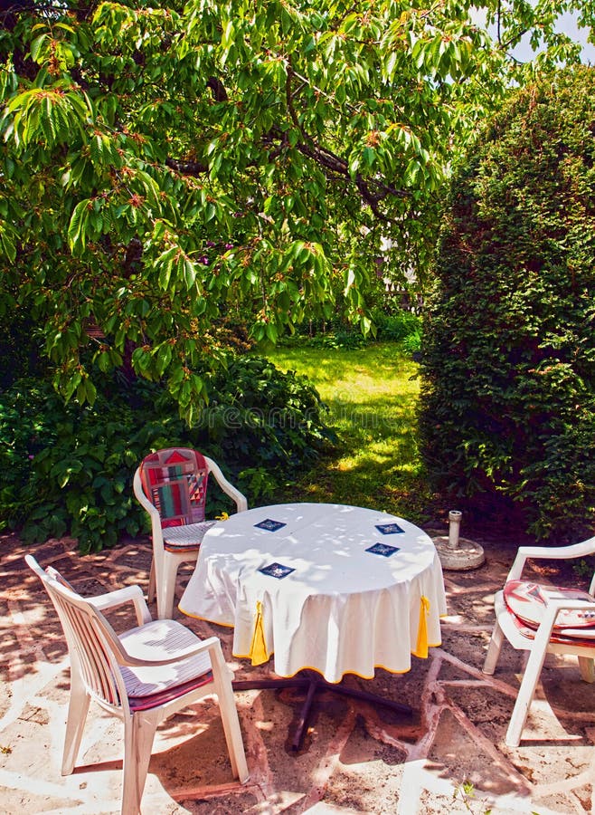 Table and Seats in the Garden Under Cherry Tree Stock Image - Image of ...