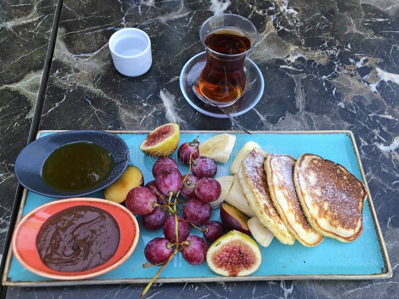 Table Set with Tea, Bread, Figs, and Assorted Condiments in a Rustic ...