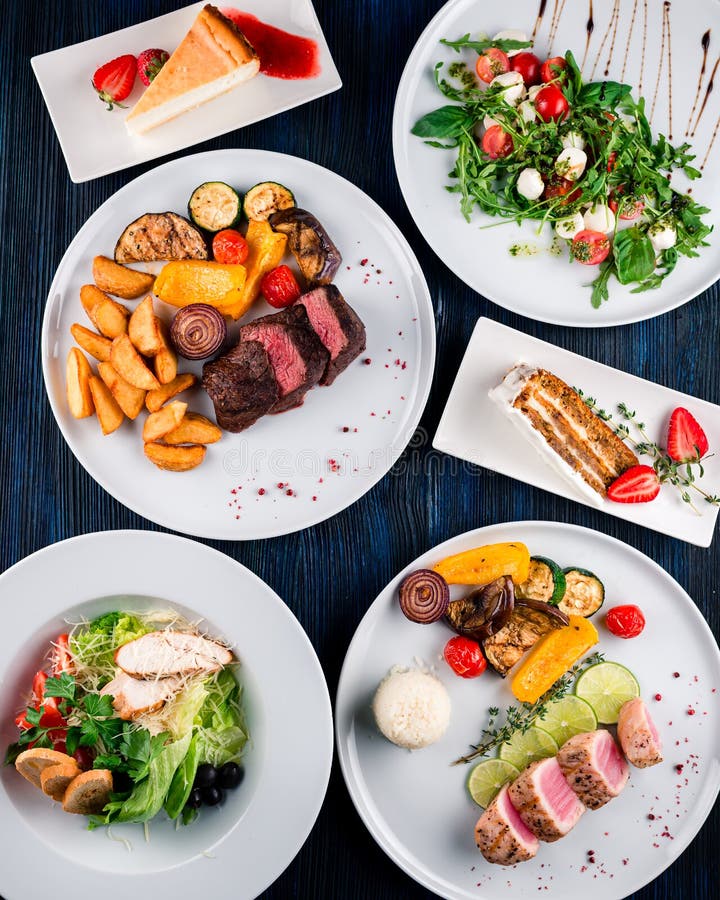Table Set for Two with a Main Course, Salad and Dessert Stock Image ...