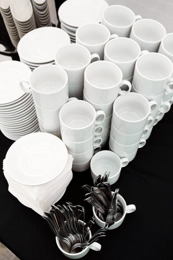 A Table Set of White Mugs, Plates and Spoons on a Buffet Stock Photo ...