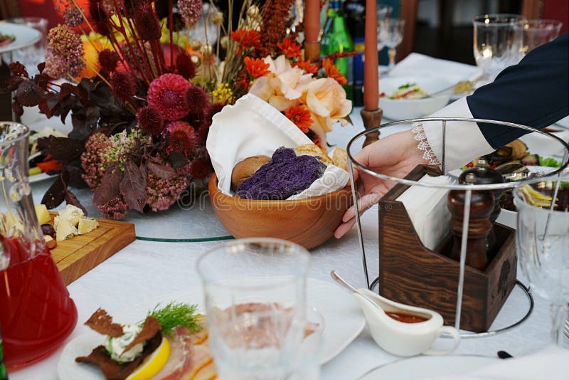 Table Setting for a Festive Dinner. Waiter Places a Plate of Bread on ...
