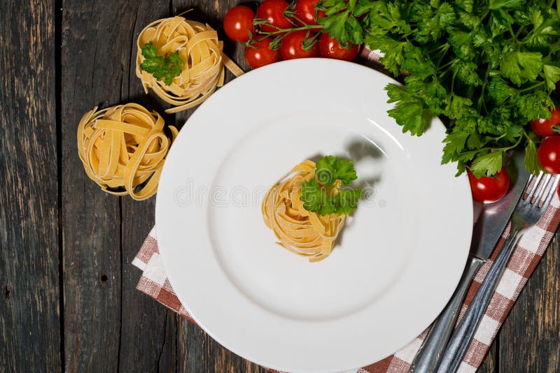 Table Setting with White Plate, Pasta and Vegetables on a Wooden Table ...