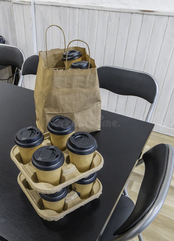 A Table with a Stack of Coffee Cups and a Brown Paper Bag Stock Image ...