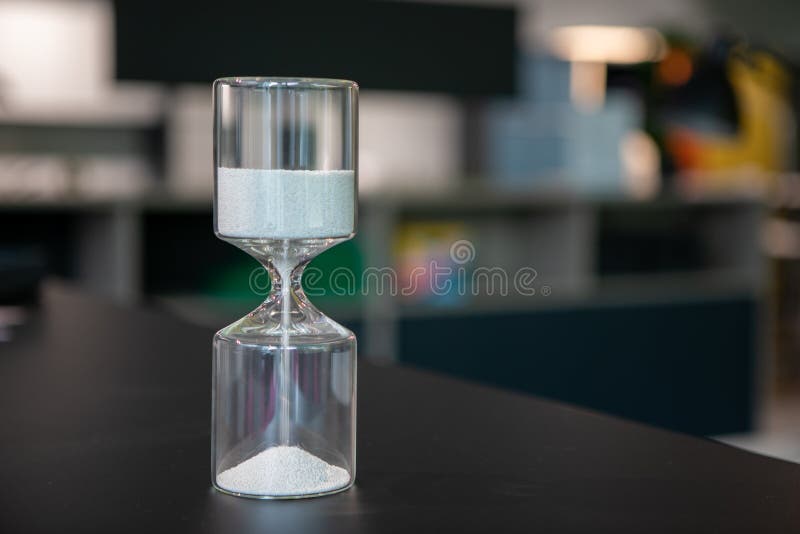 On a Table Stand an Egg Timer Made of Glass, Which is Filled with Small ...