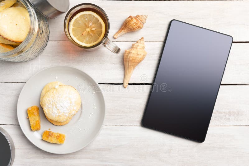 Table Top Scene with Lemon Butter Biscuits, a Tablet and Lemon Tea ...