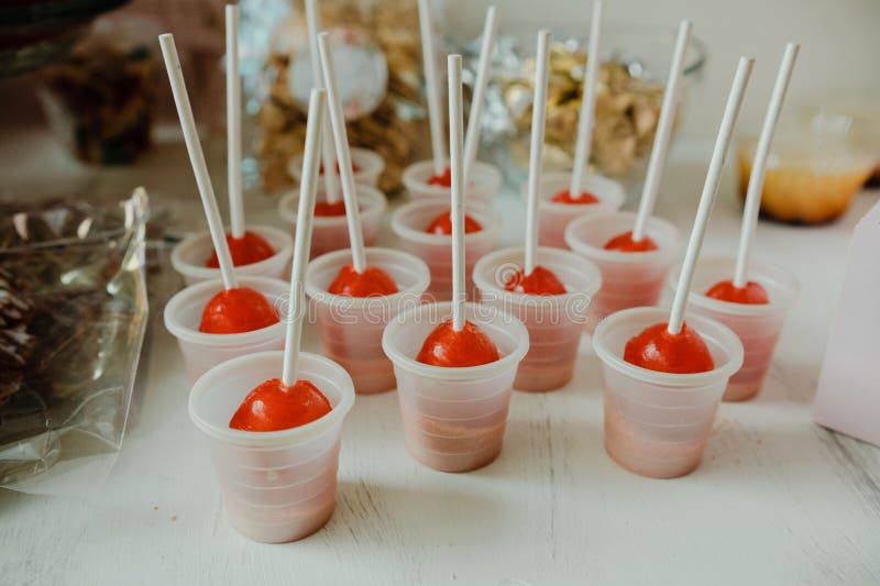 Table Topped with Plastic Cups Filled with Candy Pops and Desserts ...