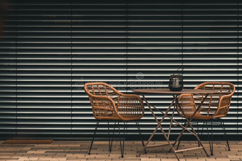 Table with Two Chairs on a Terrace in Front of Blinds. Urban or ...