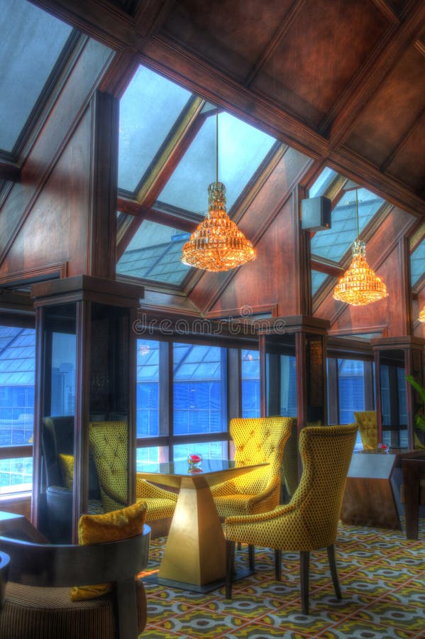 Tables and Lounge Chairs with Hanging Lights in a Comfortable Lounge ...