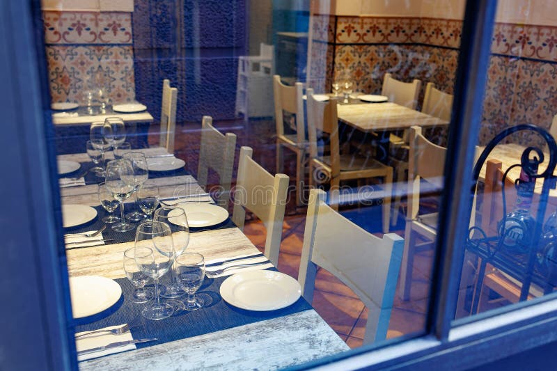 Tables Set Inside a Small Restaurant with Walls Decorated with Colorful ...
