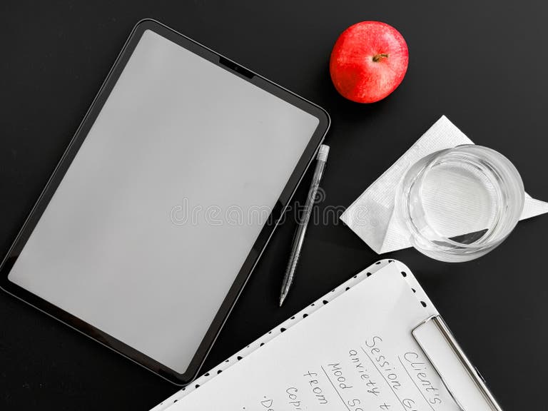 Tablet on Black Desk with Apple, Water, Pen, and Notepad Stock Image ...