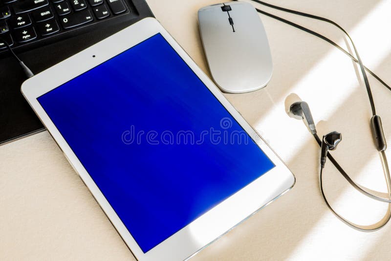 Tablet with Blue Screen on the Keyboard of a Laptop on a Desk ...