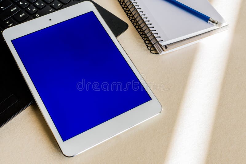 Tablet with Blue Screen on the Keyboard of a Laptop on a Desk ...