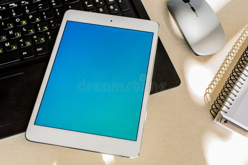 Tablet with Blue Screen on the Keyboard of a Laptop on a Desk ...