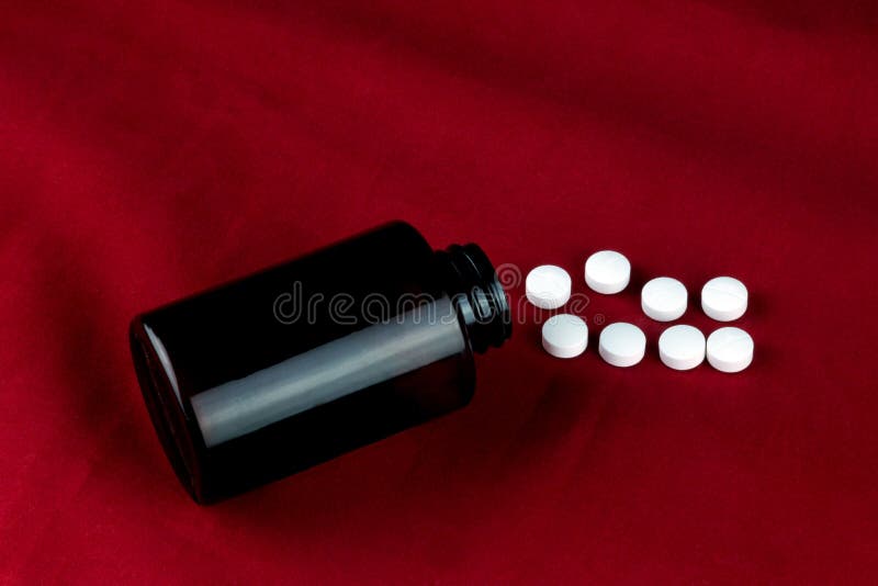 Tablet Bottle and Spilled Tablets on a Red Table Cloth Stock Image ...