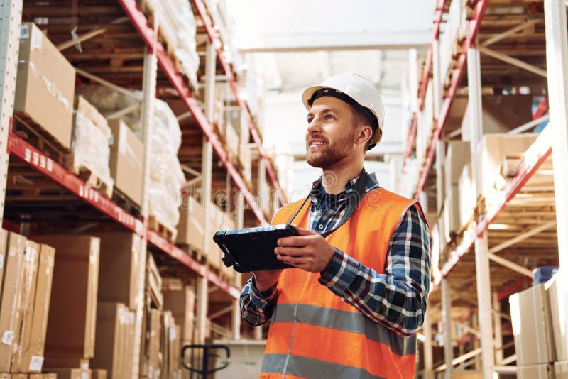 With Tablet. Employee in Uniform is Working in the Storage at Daytime ...