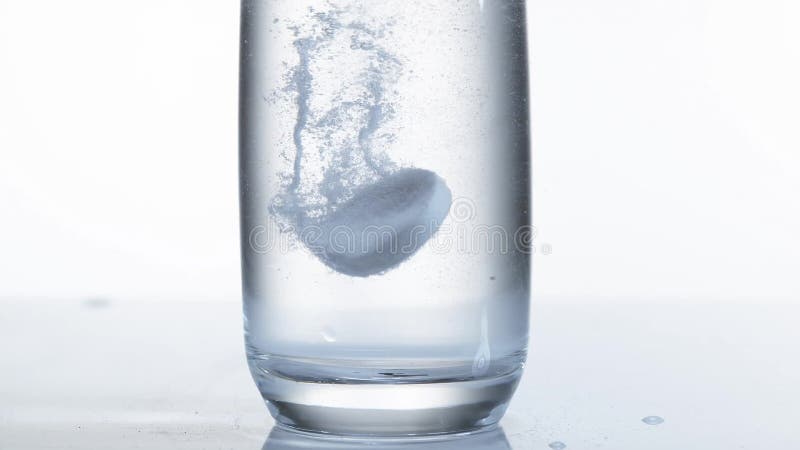 Tablet Falling and Dissolving into a Glass of Water Against White ...