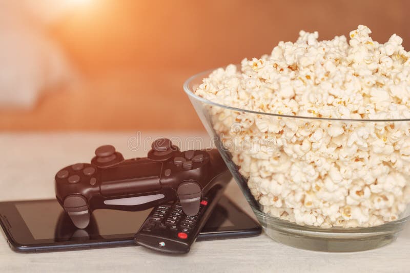 Tablet and Joystick, Remote Control TV Next To Popcorn on Table Stock ...