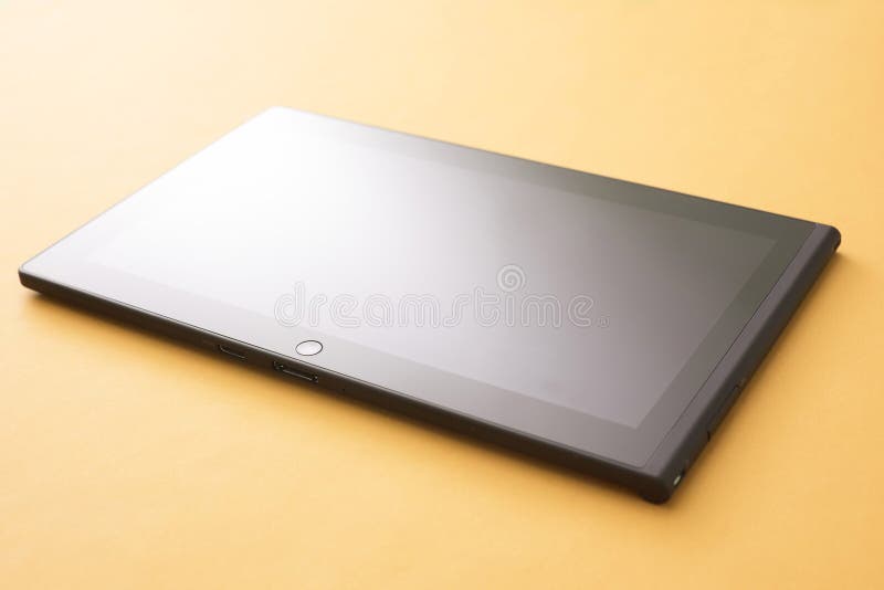 Tablet Mobile Device with Blank Black Screen Close-up on Yellow Surface ...