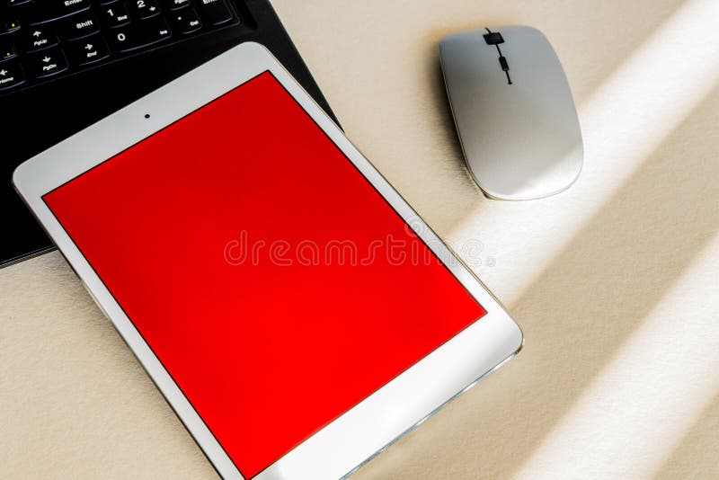 Tablet with Red Screen on the Keyboard of a Laptop on a Desk ...