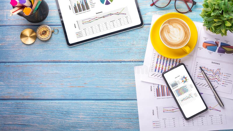 Tablet and Smart Phone with Charts and Reports on Office Desk Workplace ...