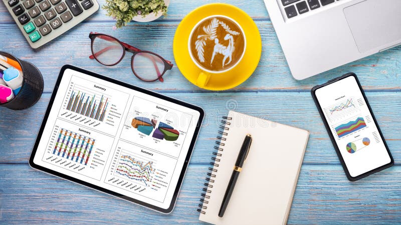 Tablet and Smartphone with Charts and Reports on Wooden Desk Workplace ...