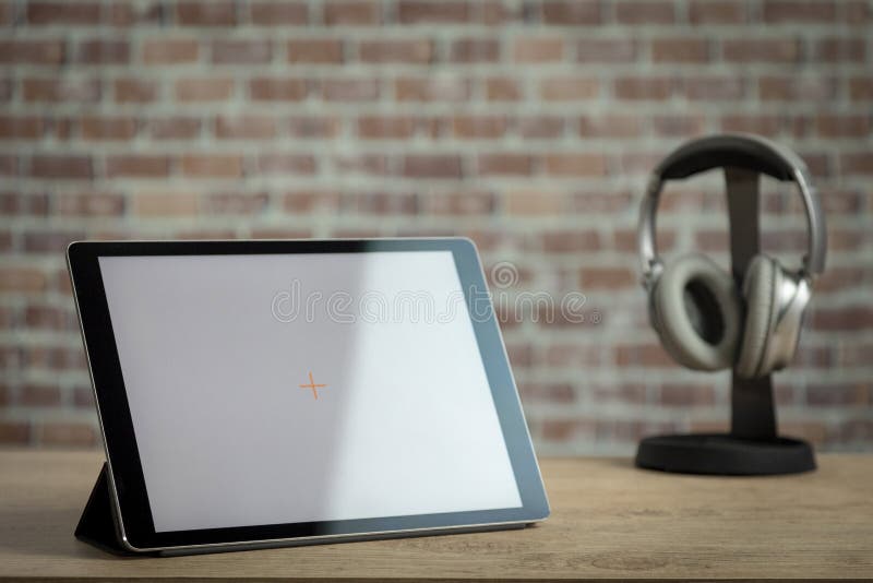 Tablet Standing on a Wooden Table in Front of a Brick Wall Stock Photo ...