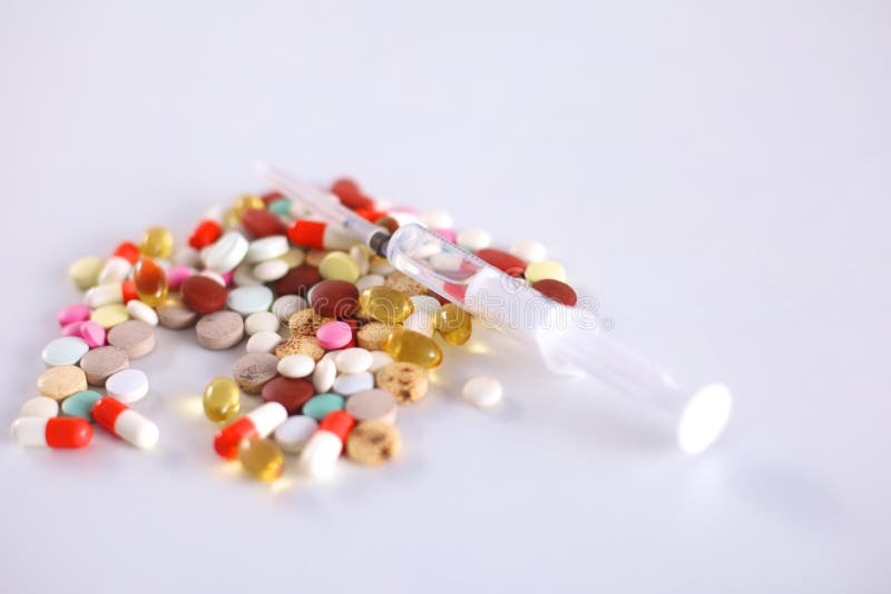 Tablets and a Syringe Lying on a White Table Stock Image - Image of ...