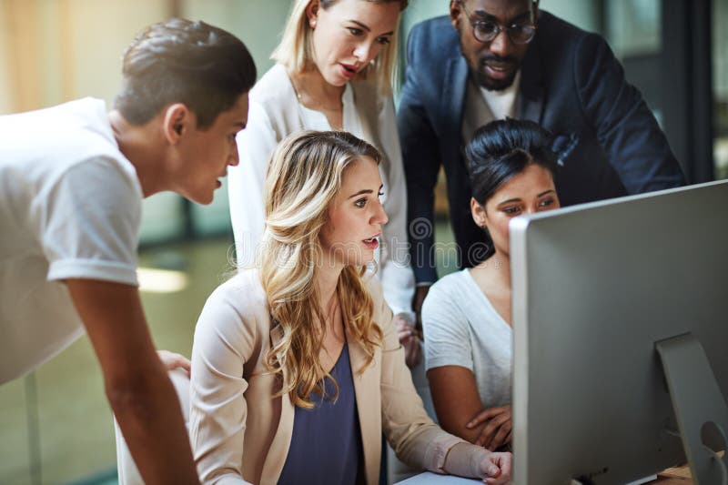 Tackling the Problem As a Team. Shot of a Group of Colleagues Using a ...