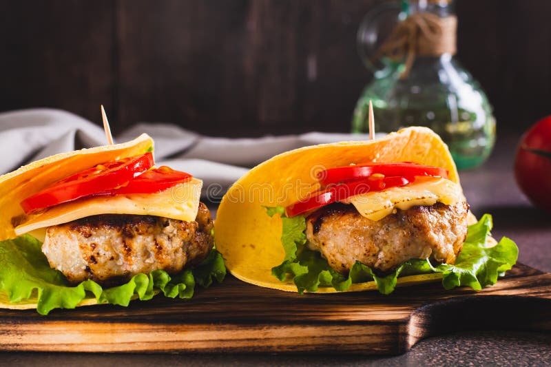 Taco Burger with Cutlet, Cheese and Tomatoes on a Board on the Table ...