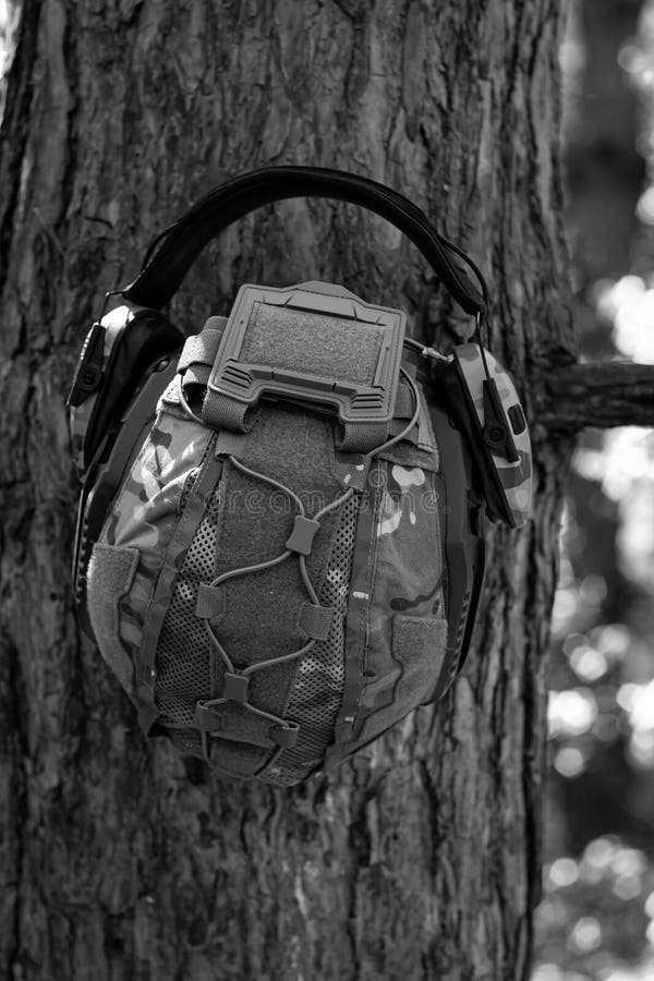 A Tactical Helmet and Active Tactical Headphones Hang on a Tree Branch ...