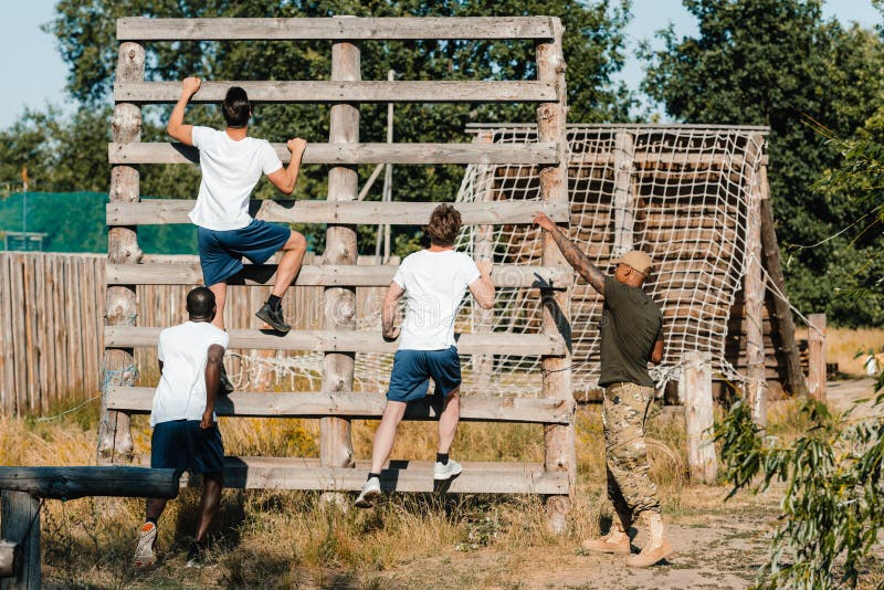 Tactical Instructor Examining Multiracial Soldiers during Obstacle Run ...