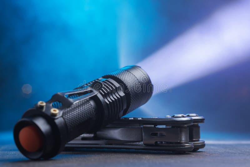 Tactical Waterproof Flashlight. LED Flashlight Shines on the Table in ...