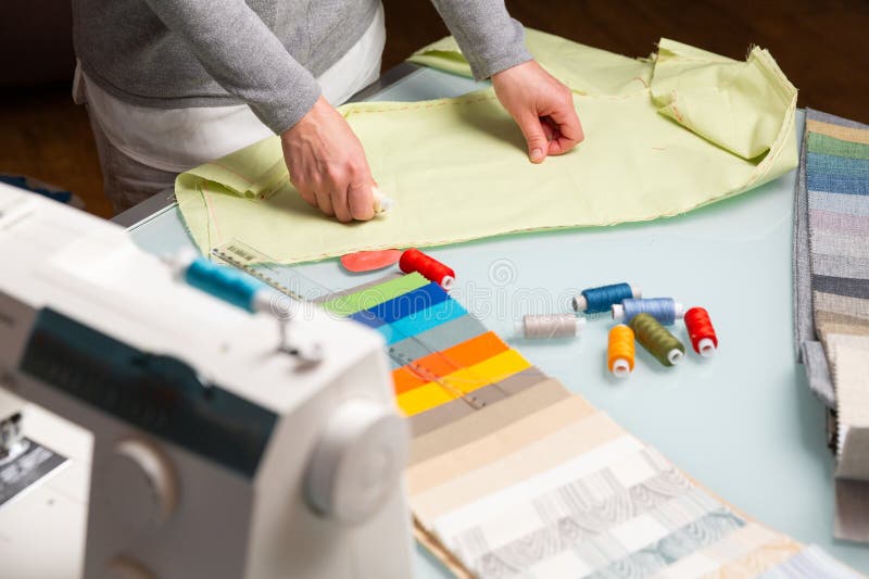 Tailor Choosing Right Color of a Thread Using Fabric Samples on Table ...
