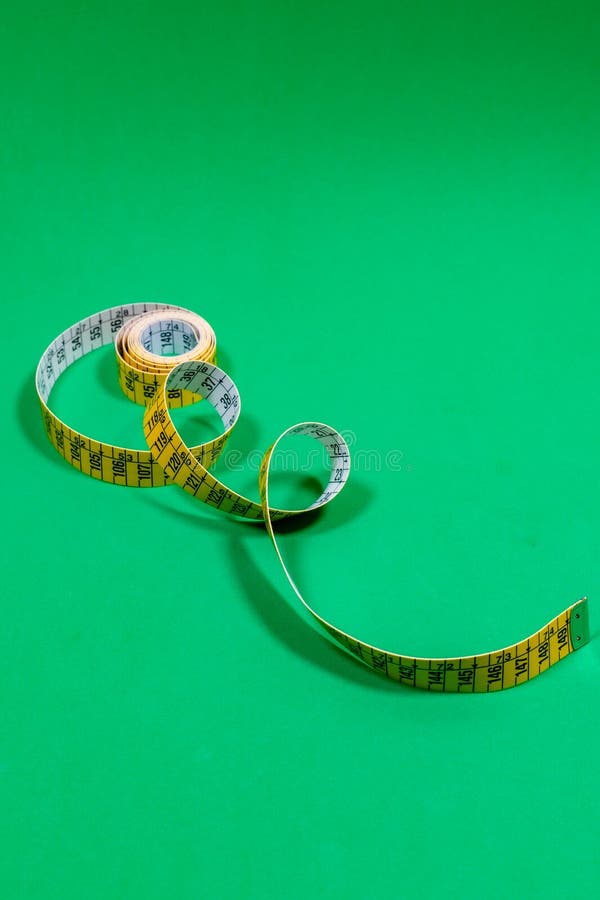 Tailor Measuring Tape in Spiral Rounds Placed on Green Surface Stock ...