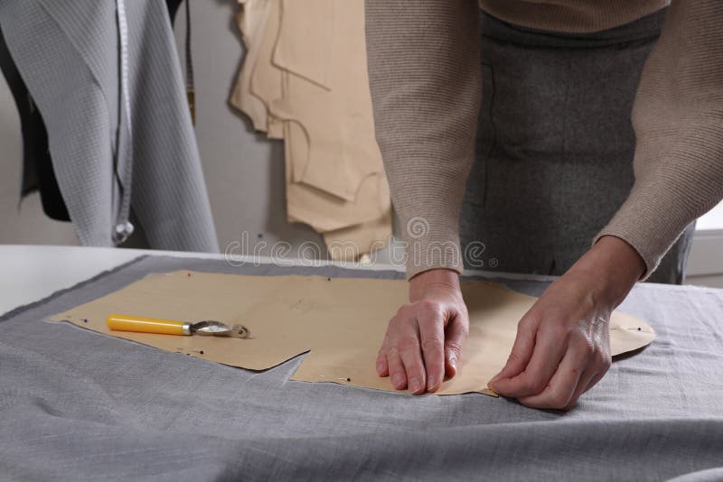 Tailor Pinning Sewing Pattern To Fabric at Table in Atelier, Closeup ...