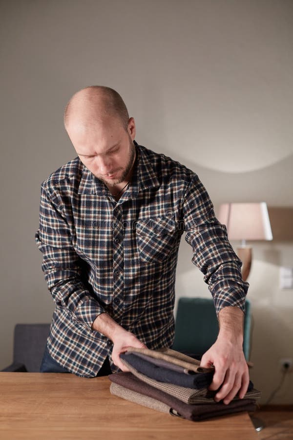 Tailor Selects Wool from the Stack. Young Man Working As a Tailor and ...