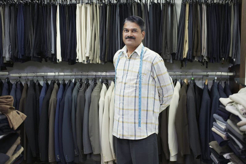 Tailor Standing in Shop in Front of Clothes Racks Portrait Stock ...