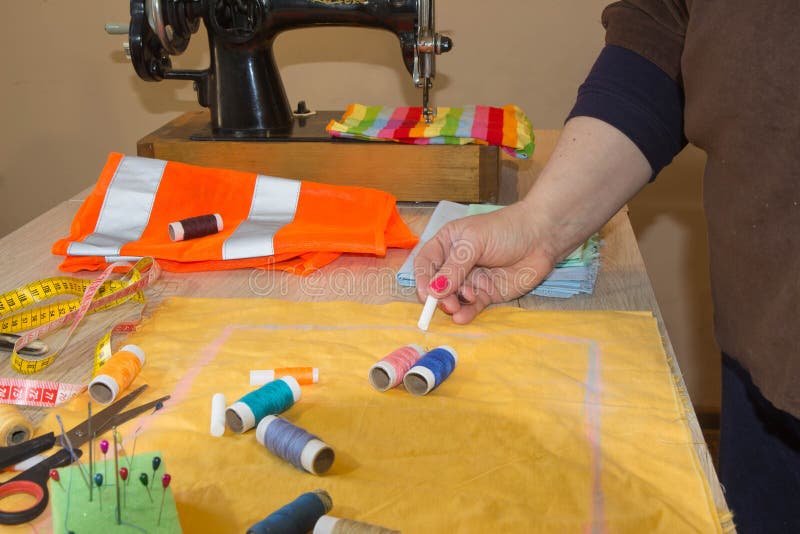 Tailor Working in His Shop. Fabric he Has Marked Out the Pattern of the ...