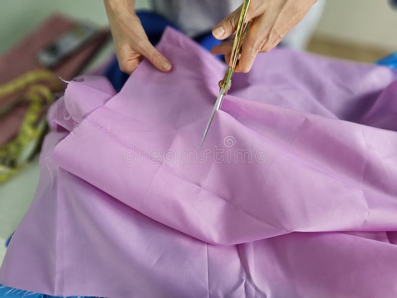 Tailoring Process with Hands Cutting Pink Fabric Using Scissors in a ...