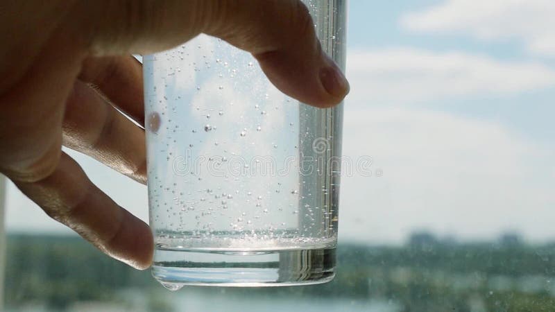 Take Glass with Water on Blurred Blue Sky Background in Slowmotion ...