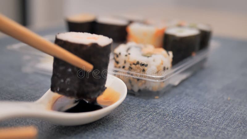 Take a Roll with Chopsticks and Dip it in Soy Sauce Stock Photo - Image ...