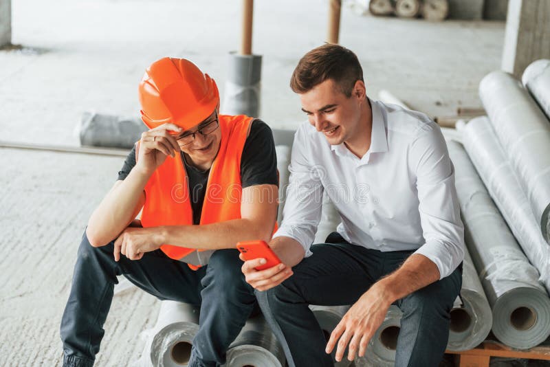 Taking a Break. Man in Suit and Handyman in Orange Protective Wear is ...