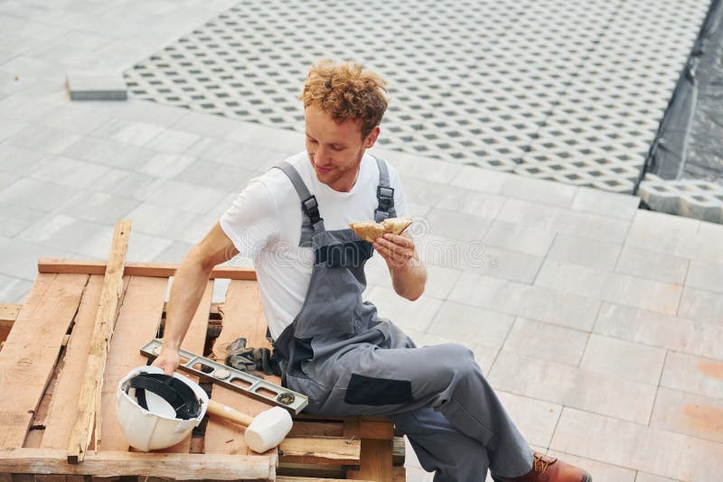 Taking a Break. Young Man Working in Uniform at Construction at Daytime ...