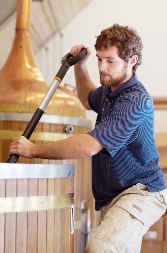 Taking Care with Every Batch. a Young Man Working on a Batch of Beer in ...