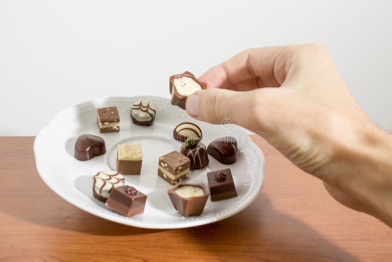 Taking a Chocolate on a Plate on a Table Stock Photo - Image of candy ...