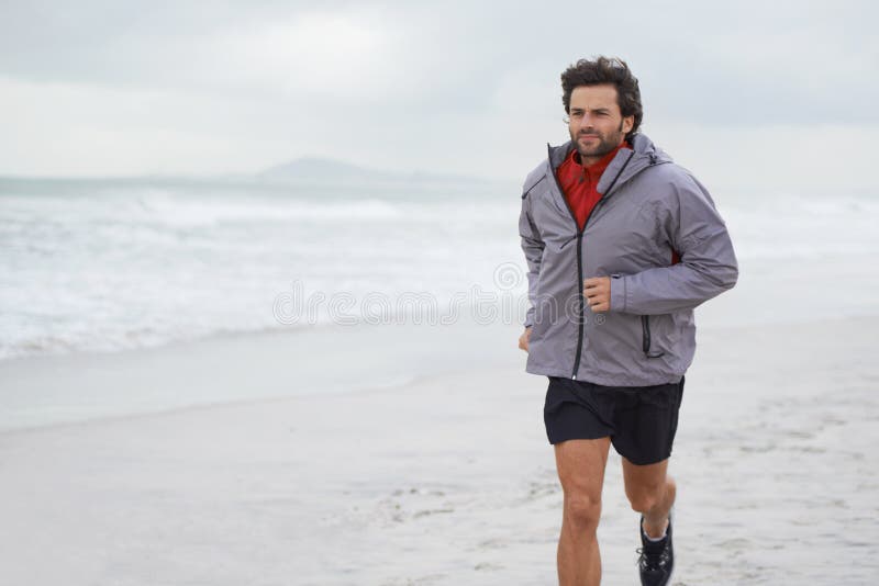 Taking a Morning Run on the Beach. a Handsome Young Man Running on the ...